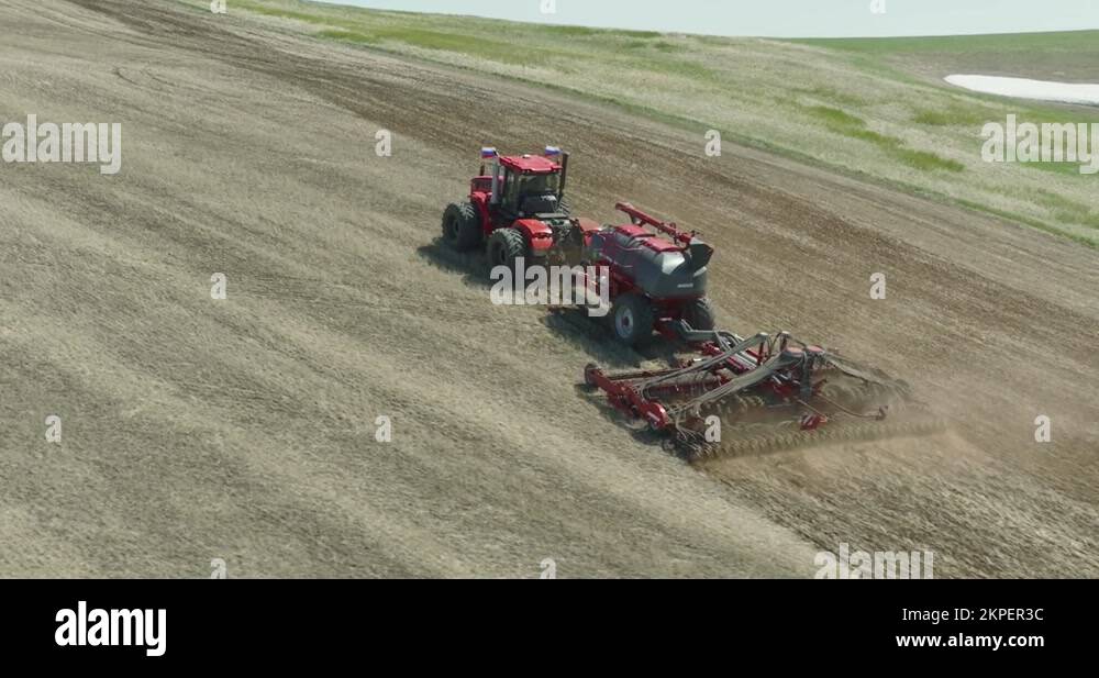 Tractor sowing seeds with seeder driller in field. Process of sowing ...