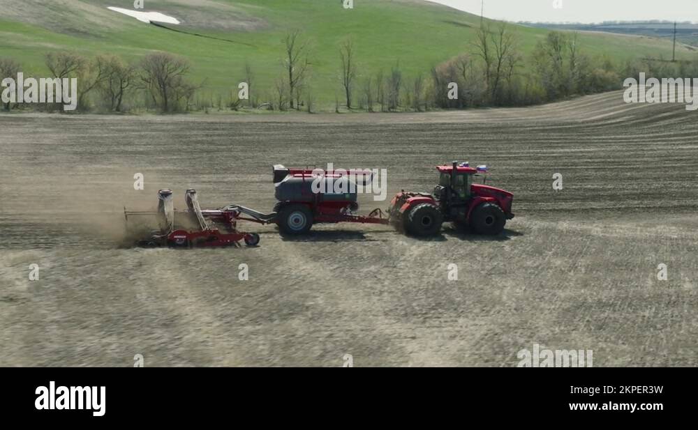 Tractor sowing seeds with seeder driller in field. Process of sowing ...