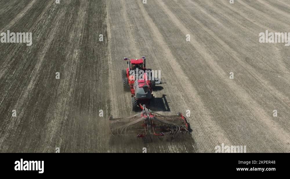 Tractor sowing seeds with seeder driller in field. Process of sowing ...