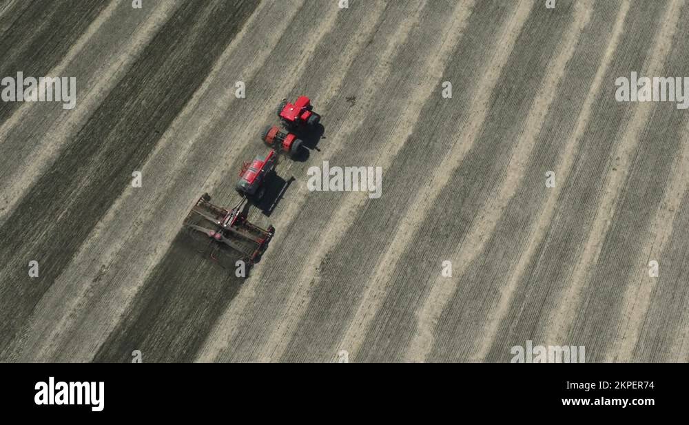 Tractor sowing seeds with seeder driller in field. Process of sowing ...