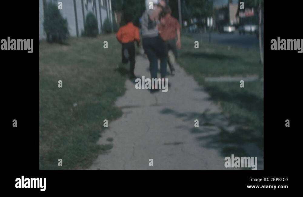 1960s: Slate. Following boys running down a sidewalk. Slate. A model of ...