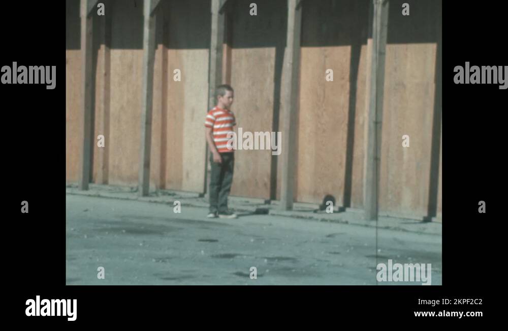 1960s: Slate. Boy walks next to a construction site. Boy climbs on a ...