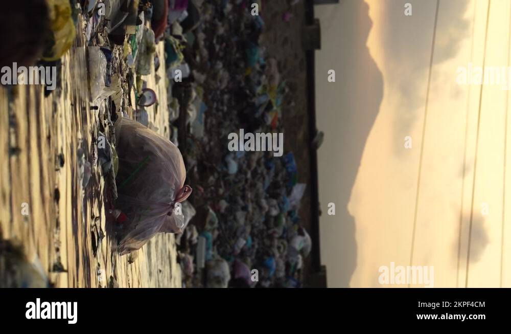 Vertical video, plastic garbage trash pollution on river bank in third ...