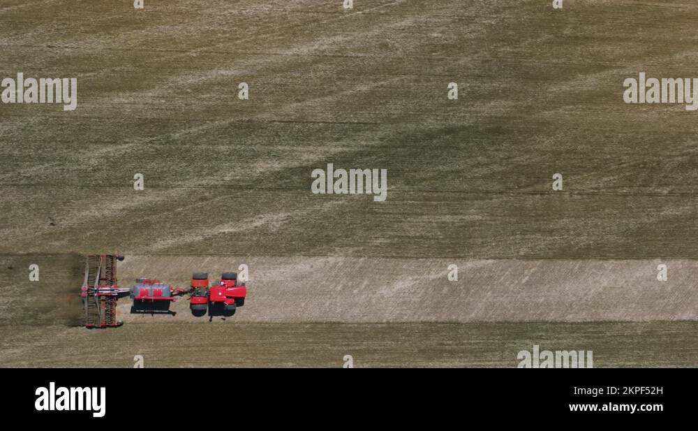 Tractor sowing seeds with seeder driller in field. Process of sowing ...