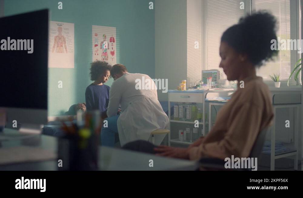 Mother Waiting Daughter Examination In Doctor Office African Girl