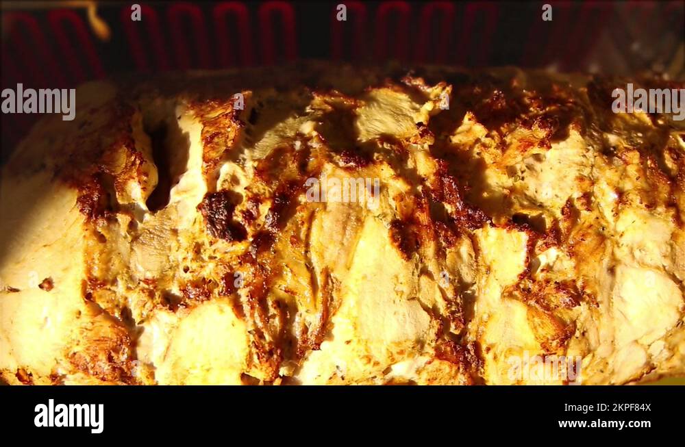 Skewered roasted chicken shawarma meat cooking and turning on rotating ...
