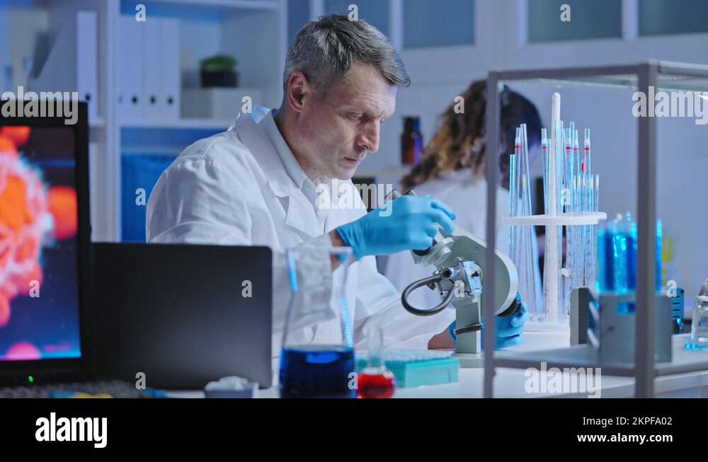 Medical scientist examining sample cell under microscope in diagnostics lab Stock Video Footage ...