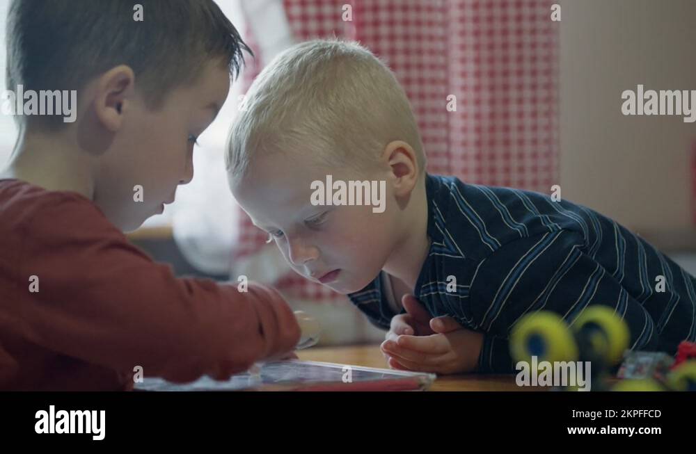 Two Caucasian boys playing games on a tablet Stock Video Footage - Alamy
