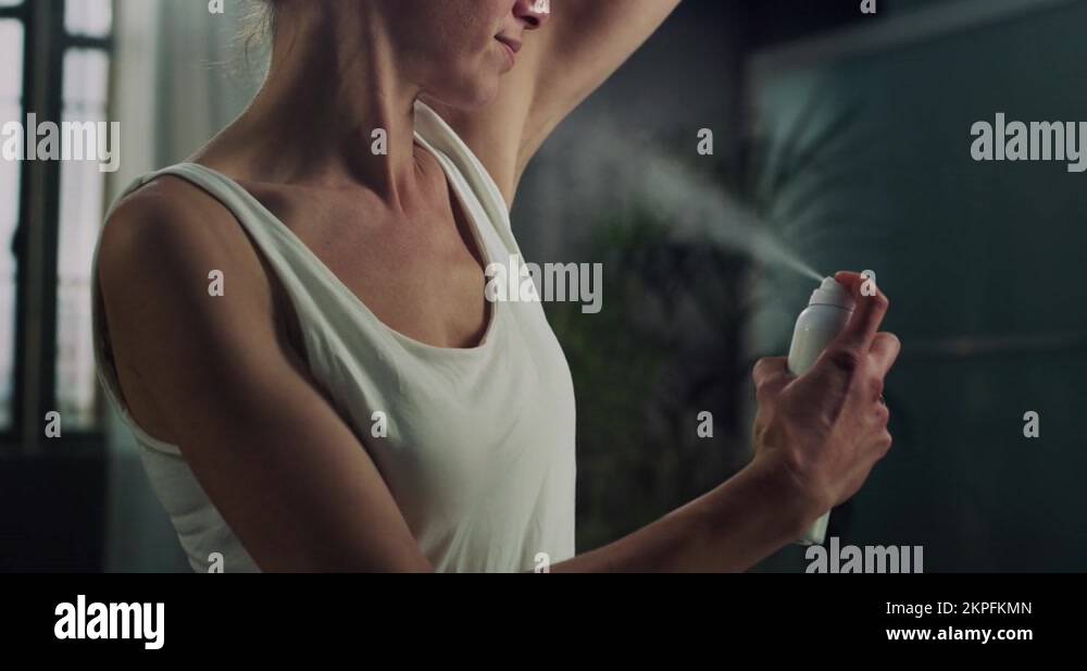 Woman applying female body dry spray deodorant on armpit and looking in mirror Stock Video ...