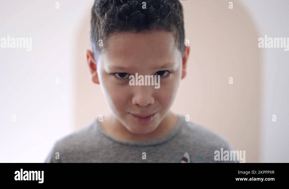 Cute 10 year old boy tries serious grumpy face but breaks expression to ...