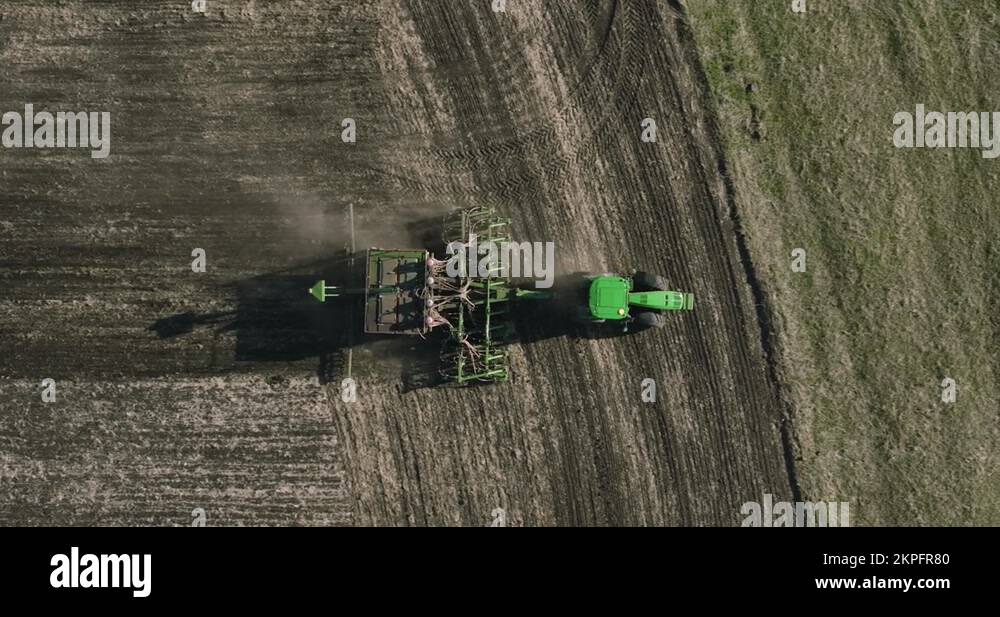 Tractor sowing seeds with seeder driller in field. Process of sowing ...