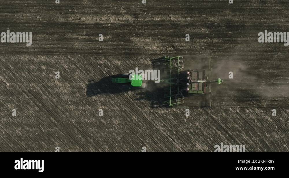 Tractor sowing seeds with seeder driller in field. Process of sowing ...