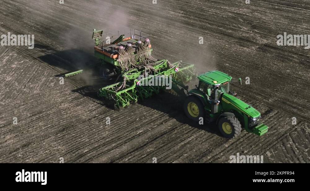 Tractor sowing seeds with seeder driller in field. Process of sowing ...