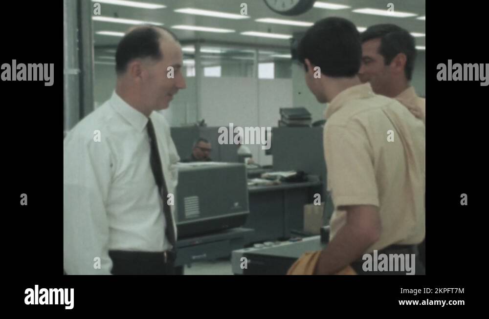1960s: Three men stand together in office, have a conversation. Men ...