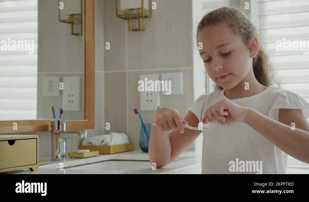 Portrait happy cute young teenage girl squeezing toothpaste onto ...