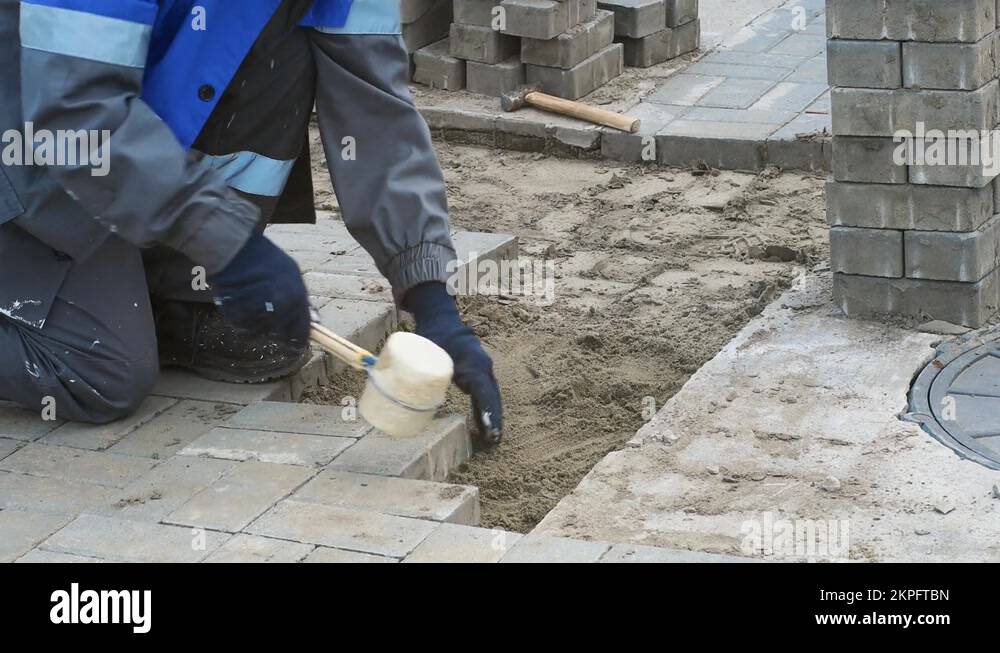 Video 4k resolution. Bricklayer lays brickwork or paving slabs on ...