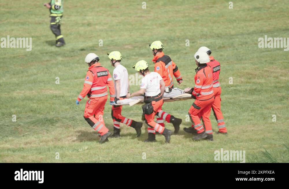 Paramedics with helmet on terrain carry a victim 4K Stock Video Footage ...