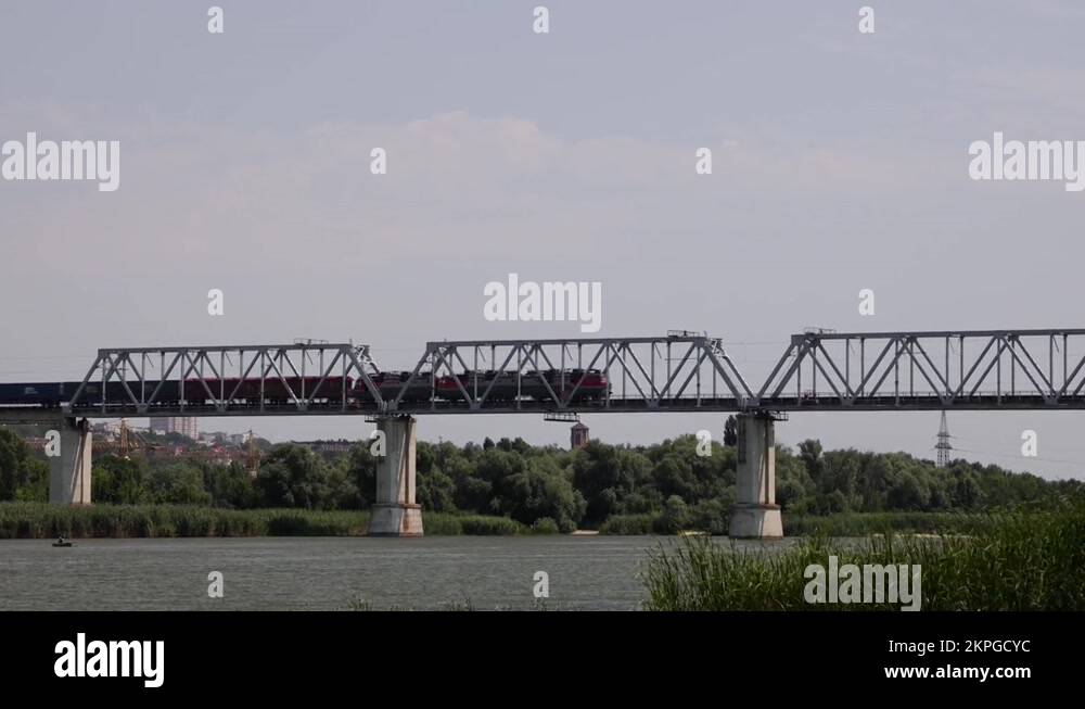 A Freight Train Rides Over A Railway Bridge Over A River On A Summer ...