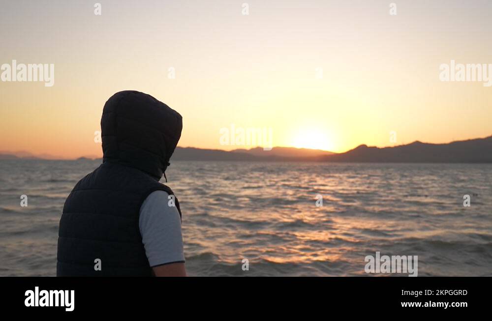 Lonely man standing alone on sunny windy sunset beach background Stock ...