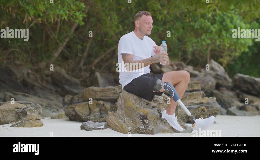 Tired man with artificial bionic legs resting after running or strength ...