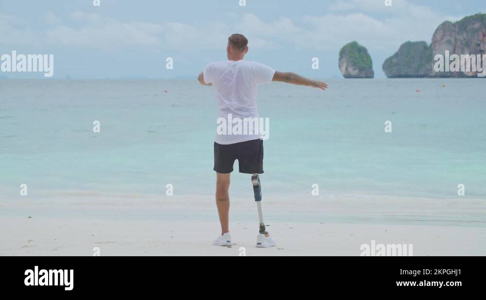 Man with artificial bionic leg doing body warm up before workout on a ...