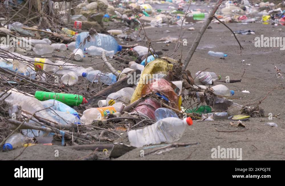 CLOSE UP: River bank polluted with piles of trashes, plastic waste and ...