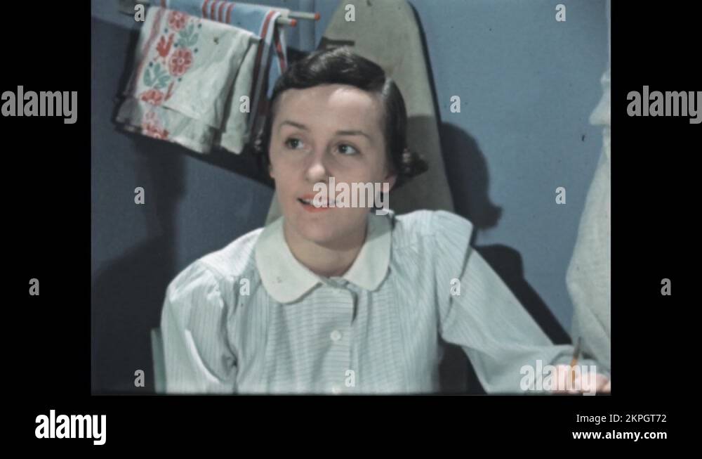 1950s: Teen girl writes in menu planning chart at kitchen table. Girl ...