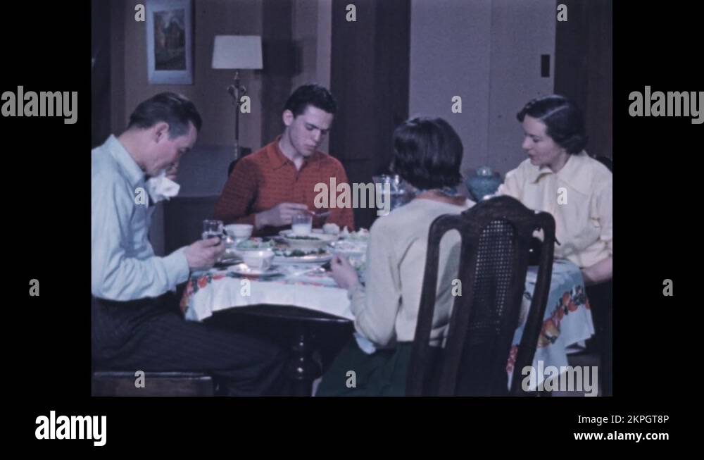 1950s: Family sits around the dinner table eating dinner and talking ...