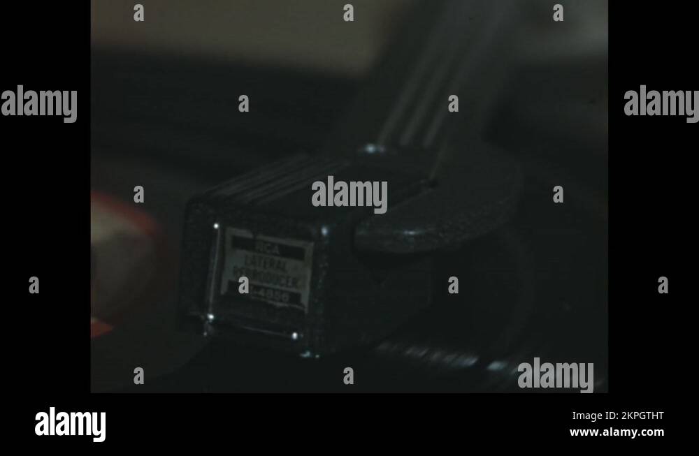 1940s: Needle on record on turntable. Young adults seated around table ...