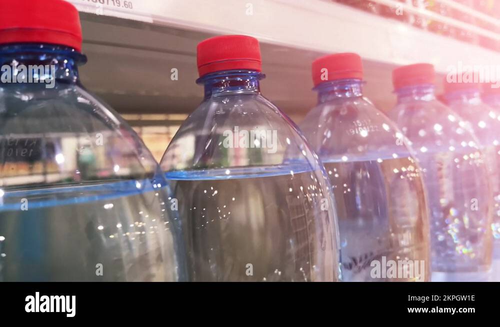 Mineral water in plastic bottles line up on the supermarket shelves or ...