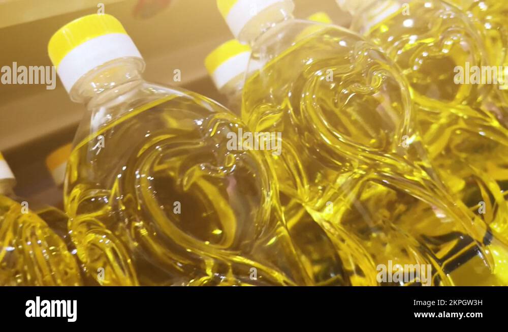 Sunflower or corn oil in plastic bottles line up on the shelf in a ...