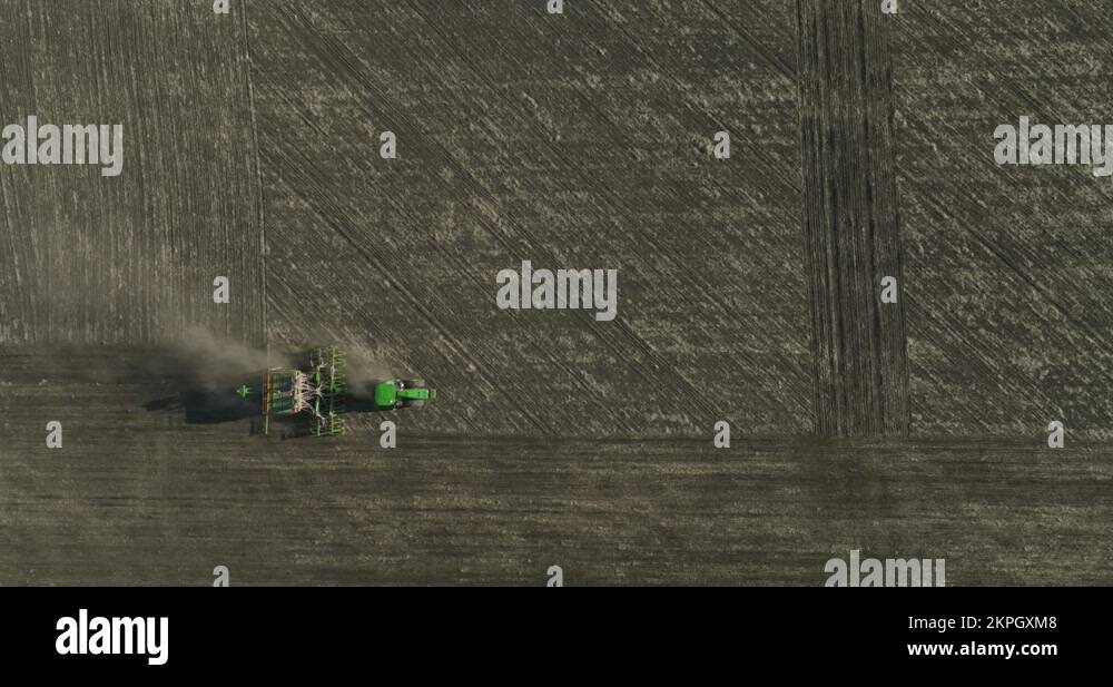 Tractor sowing seeds with seeder driller in field. Process of sowing ...