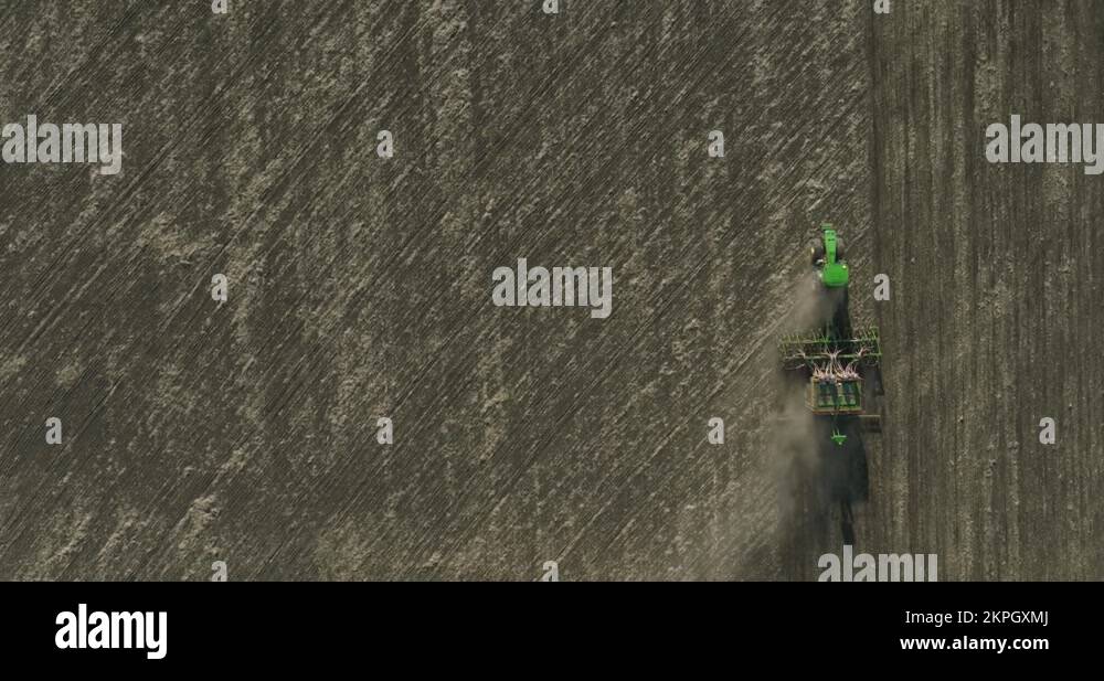 Tractor sowing seeds with seeder driller in field. Process of sowing ...