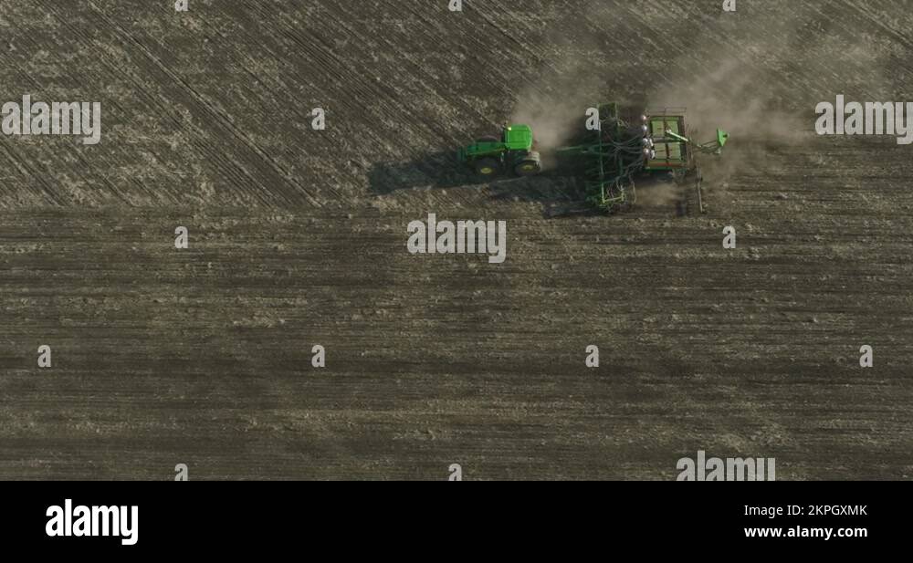 Tractor sowing seeds with seeder driller in field. Process of sowing ...