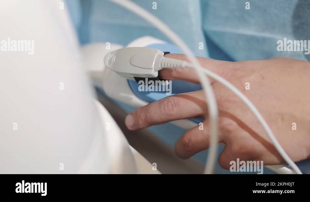 Heart rate monitor on patient's hand in operating room. Cardiograph on ...