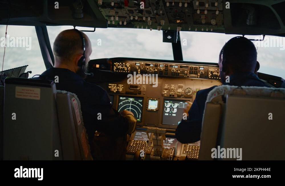 Airplane captain and copilot looking at radar compass on dashboard ...