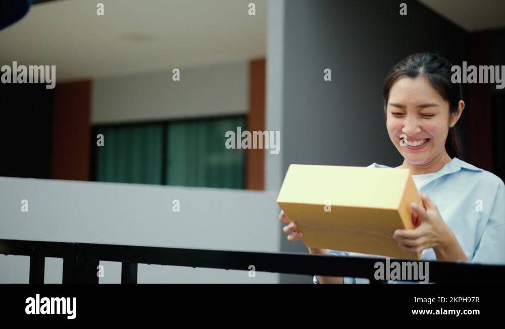 Beautiful Young Woman receiving parcel from blue uniform delivery man ...