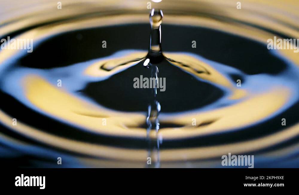 Real of water drop falls into water and diverging circles of water with ...