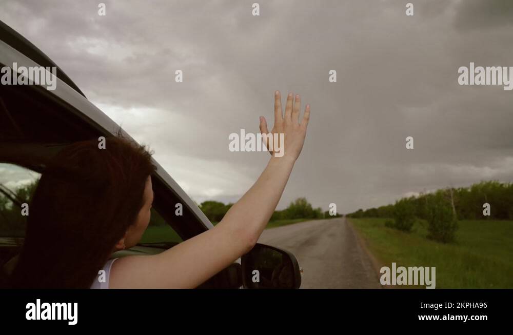 Road trip on way to vacation, Free girl waves her hand from car window ...