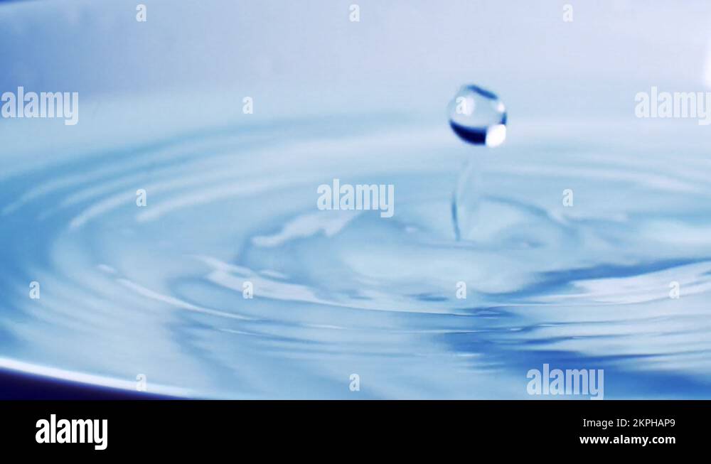 Real of water drop falls into water and diverging circles of water with ...