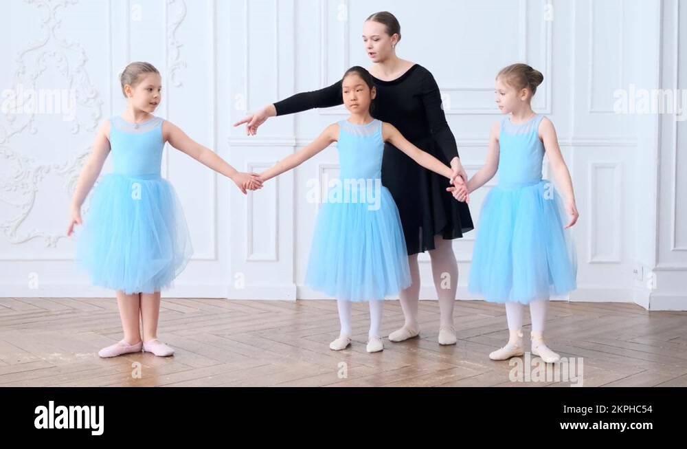 Young girls from ballet dancing ballet in white studio. Pretty graceful ...