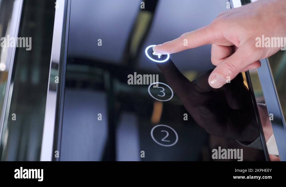 Man's hand presses a button on the modern glass elevator. Lift moving ...