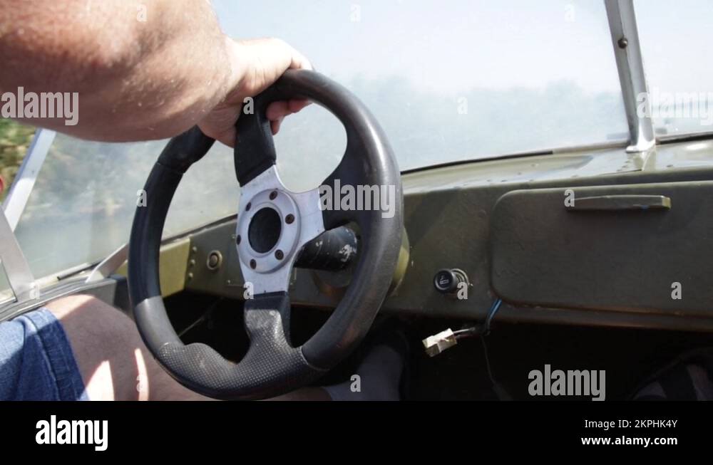 Male hand on rudder, steering wheel of motorboat floating down the ...
