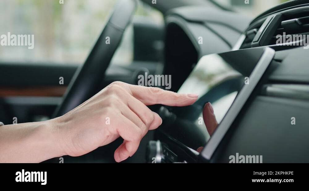 Close up shot hand of woman using touch screen in car setting up the ...