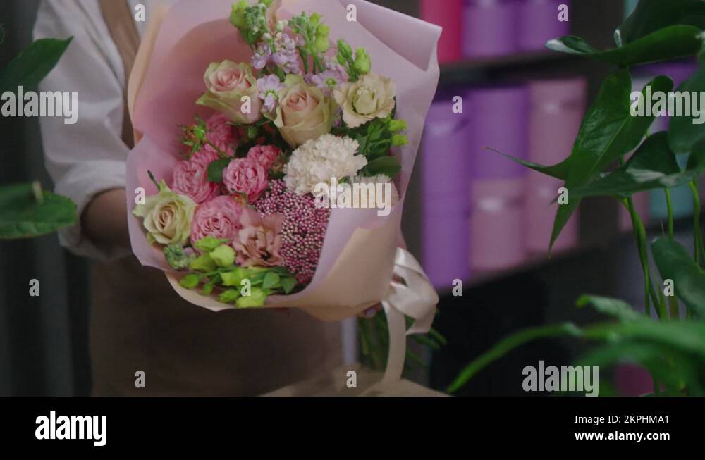 Florist shows a beautiful bouquet of flowers while working in a flower ...