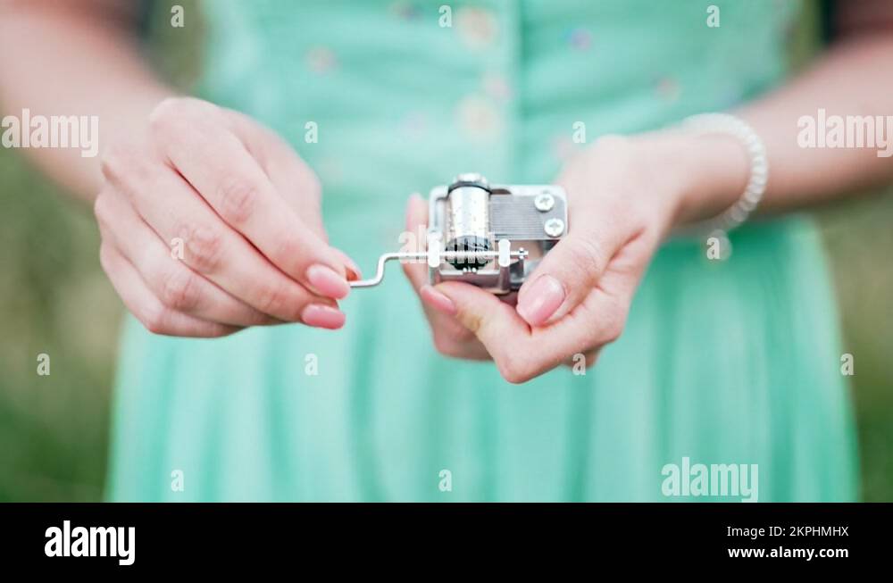 Female hands rotating gears of old music box mechanism. Lady turning ...
