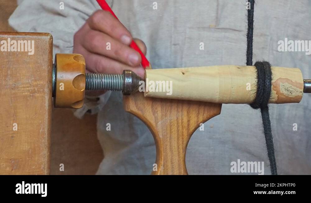 Professional craftsman using manual lathe to make tool handle, marking ...