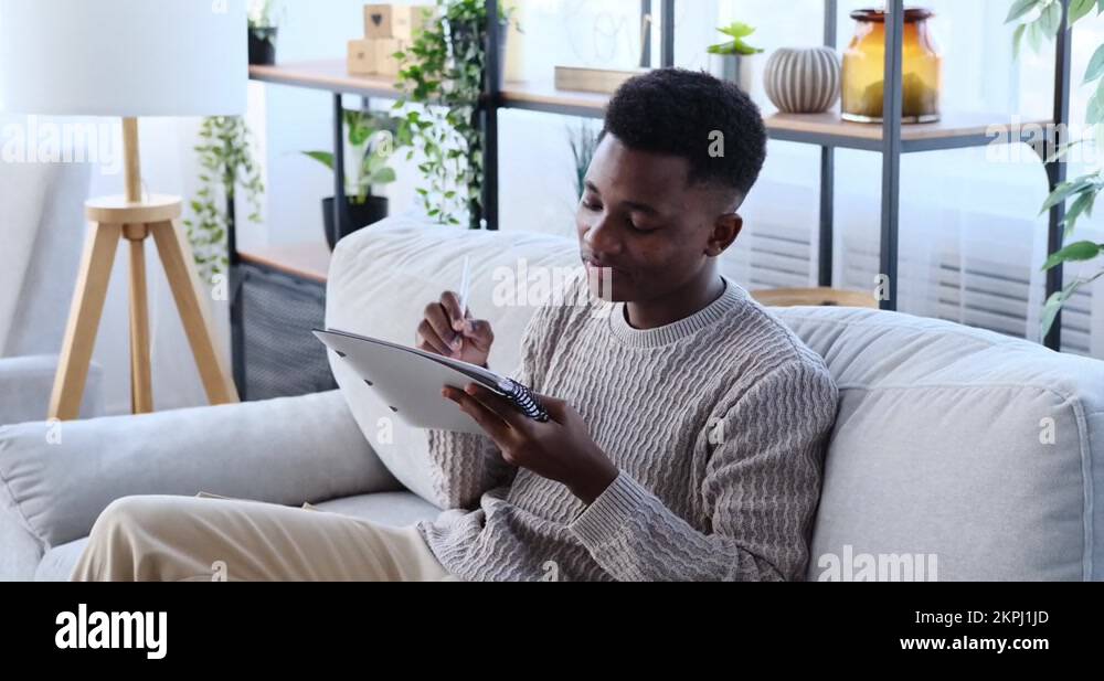 Man writing to do list in notepad sitting on sofa Stock Video Footage ...