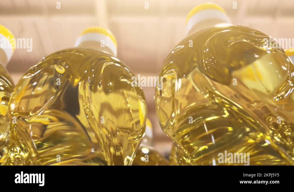 Sunflower or corn oil in plastic bottles line up on the shelf in a ...