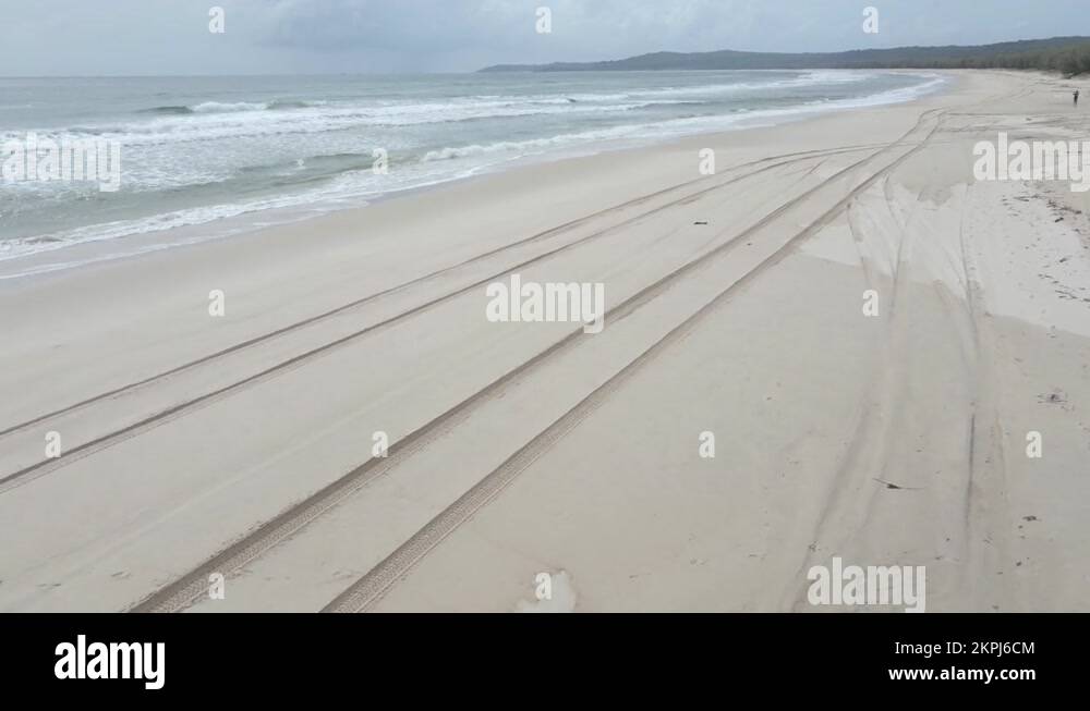 Woman In Bikini Walking On White Sand Beach With Tire Tracks In Summer ...